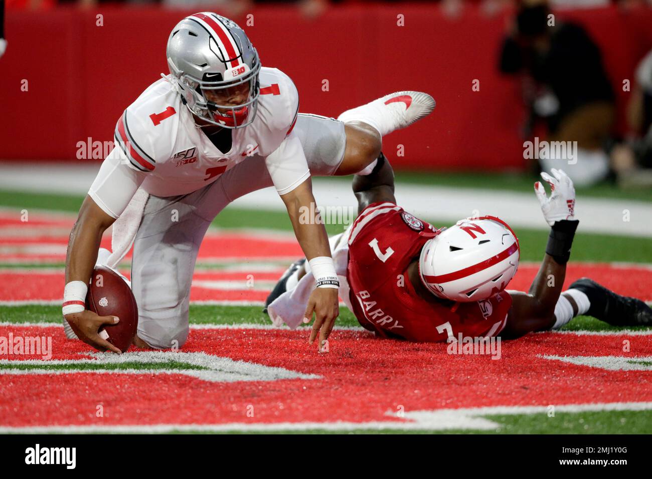 Ohio State quarterback Justin Fields (1) scores a touchdown next to ...