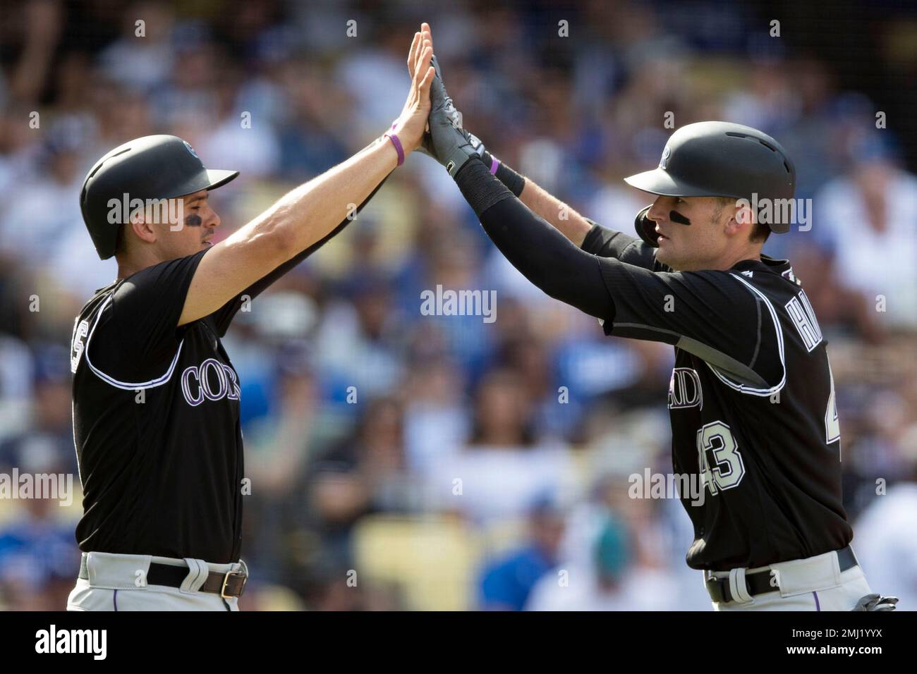 The Colorado Rockies' Josh Fuentes, left, high fives Sam Hilliard as he ...
