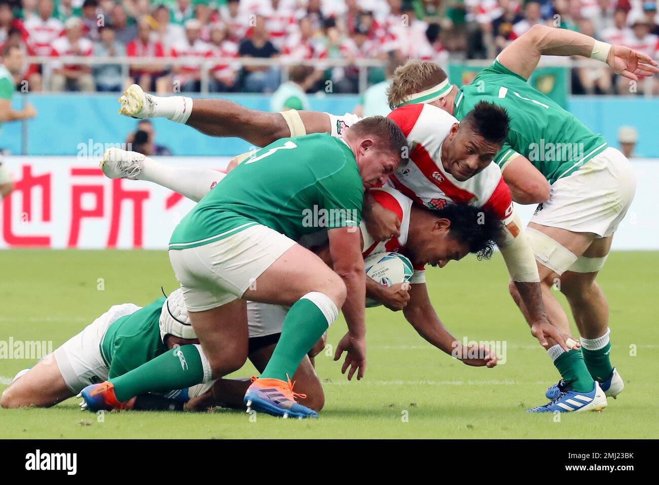 Japan's Keita Inagaki, center, runs at Ireland's defense during the ...