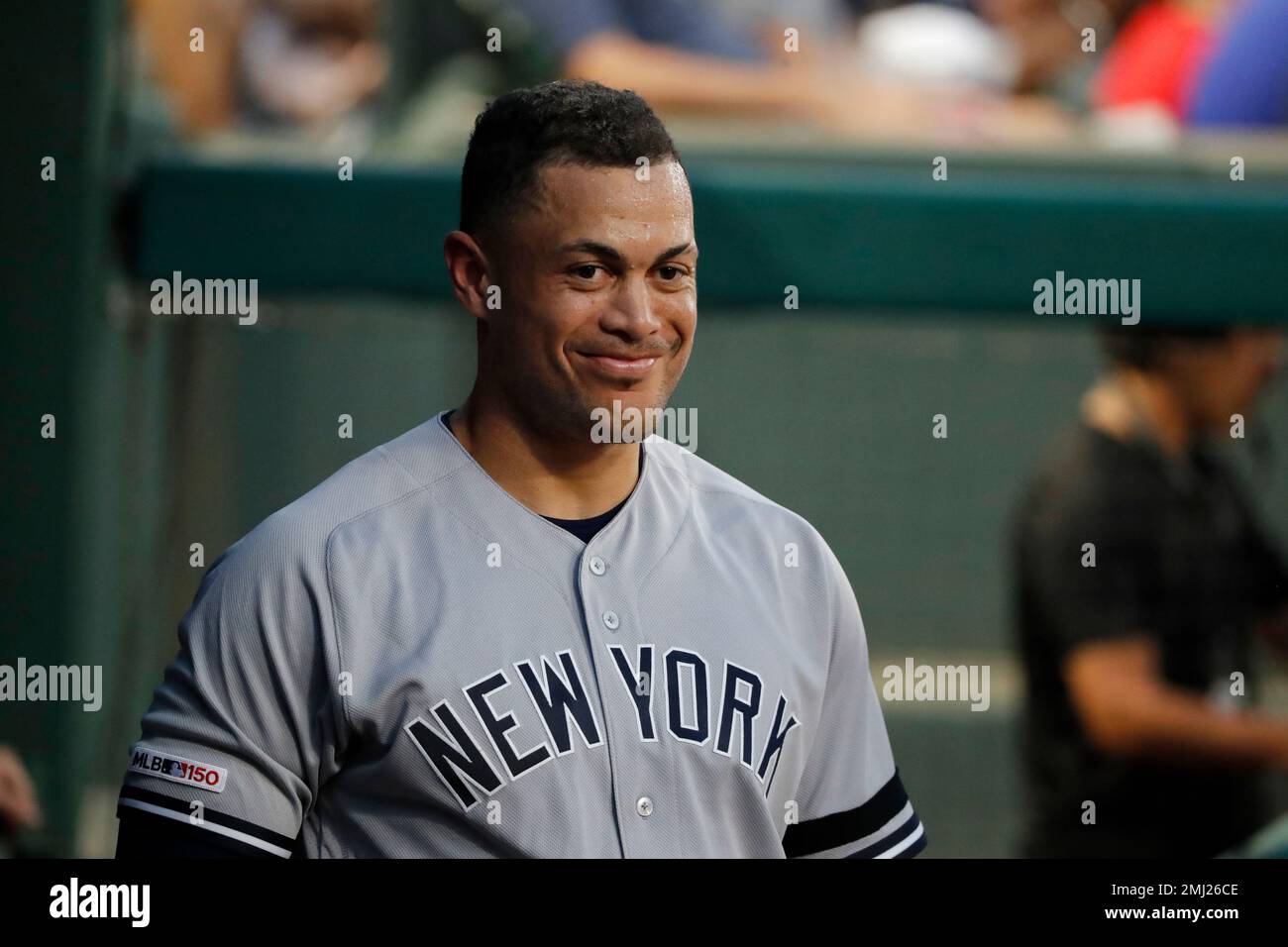 New York Yankees' Giancarlo Stanton stands in the dugout smiling after ...