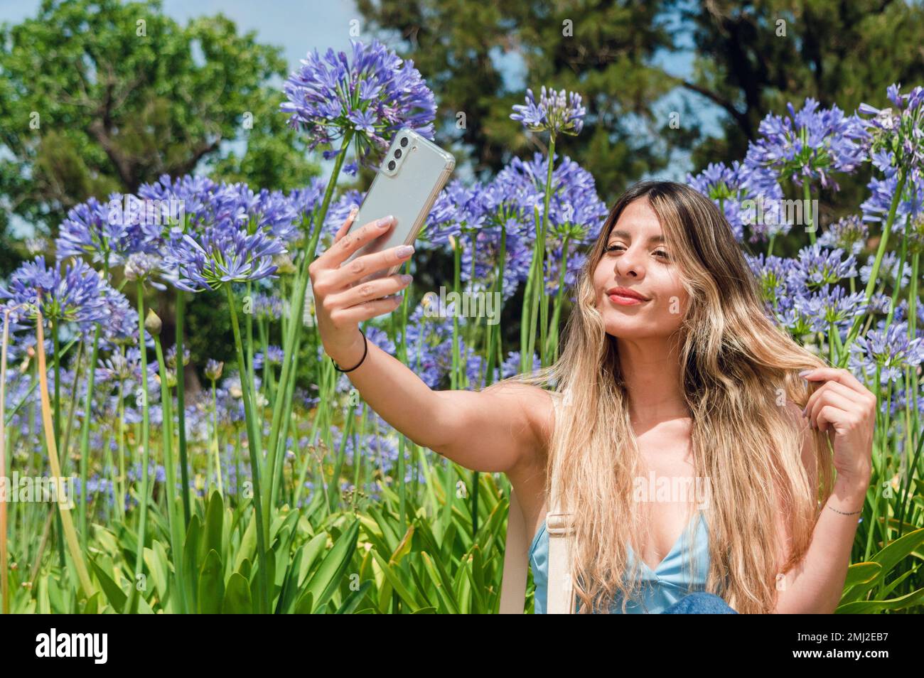 young latin colombian woman with long hair and smiling, sitting in the ...