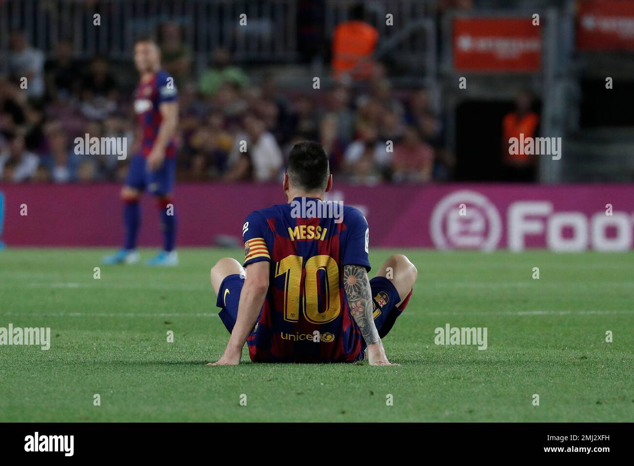 Barcelona's Lionel Messi sits on the ground after getting hurt during ...