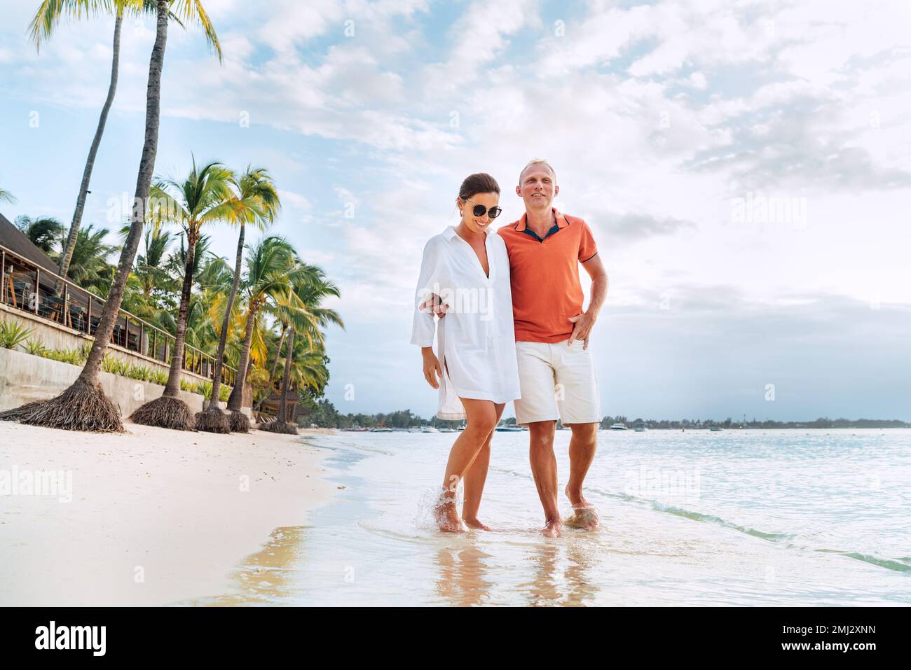 Couple in love hugging while walking on a sandy exotic beach. They have ...