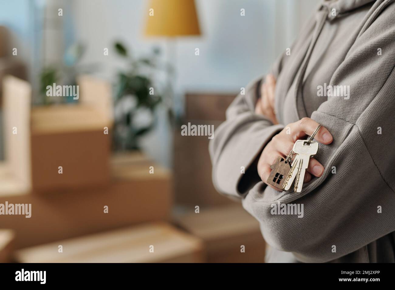 Close-up of owner standing with her arms crossed and holding keys from ...