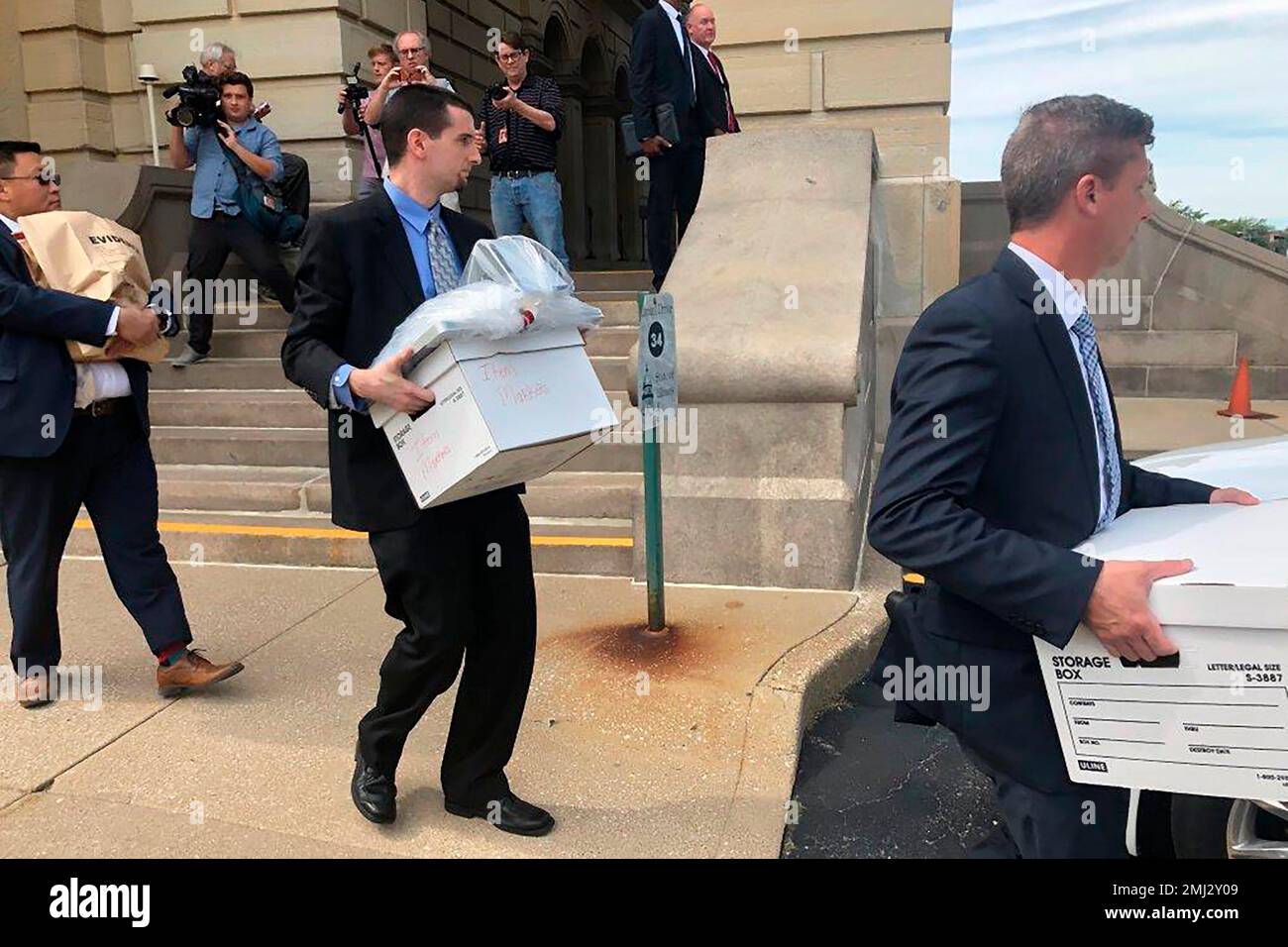 Men carrying boxes and a bag marked "evidence" leave the Illinois State ...
