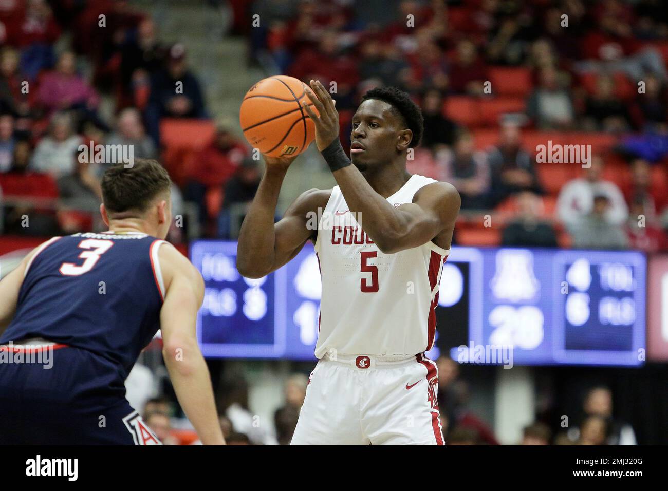 Washington State guard TJ Bamba (5) controls the ball while defended by ...