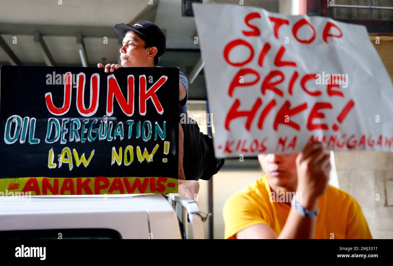 Protesters display placards to protest the oil price hike which took ...