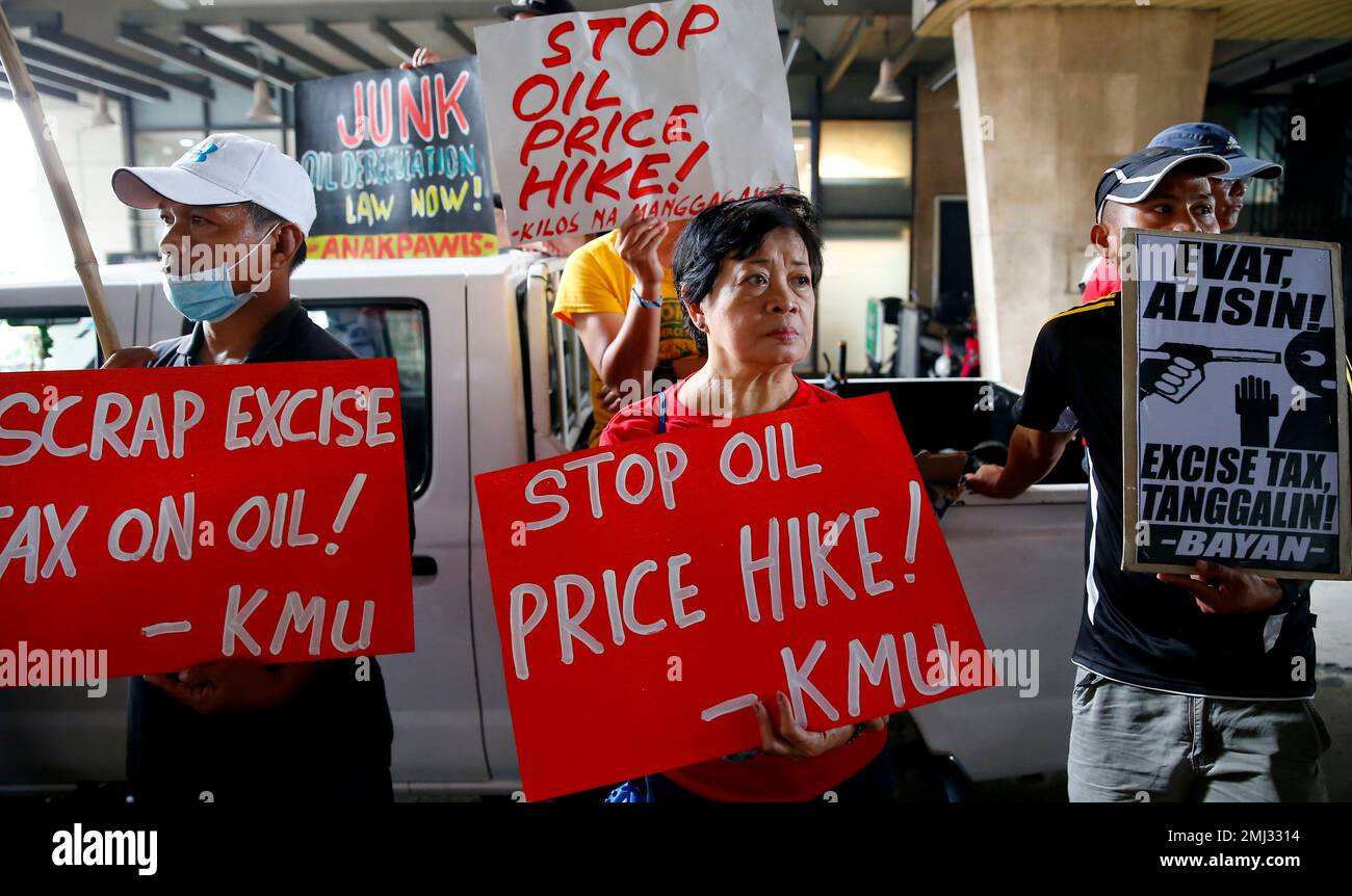 Protesters display placards during a rally to protest the oil price ...