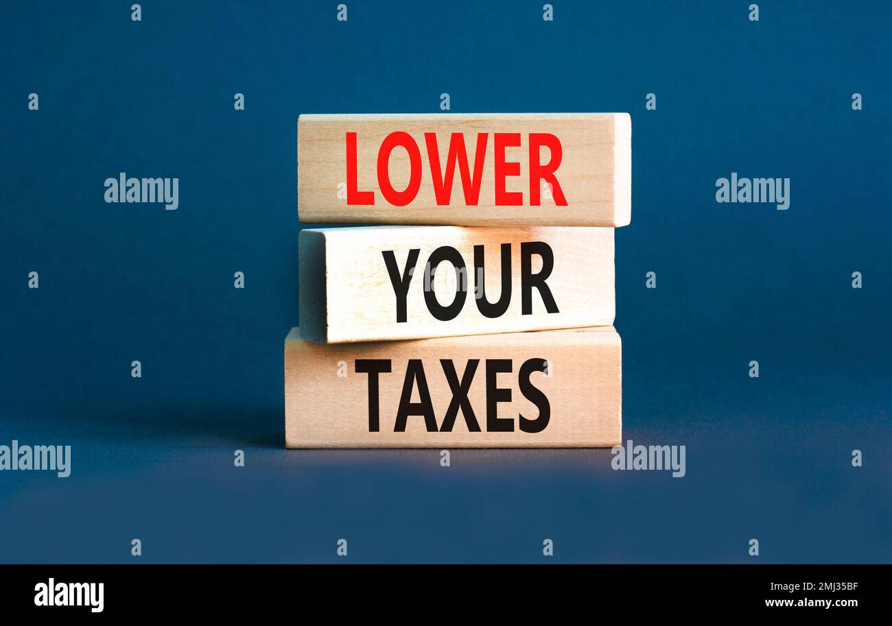 Lower your taxes symbol. Concept words Lower your taxes on wooden ...