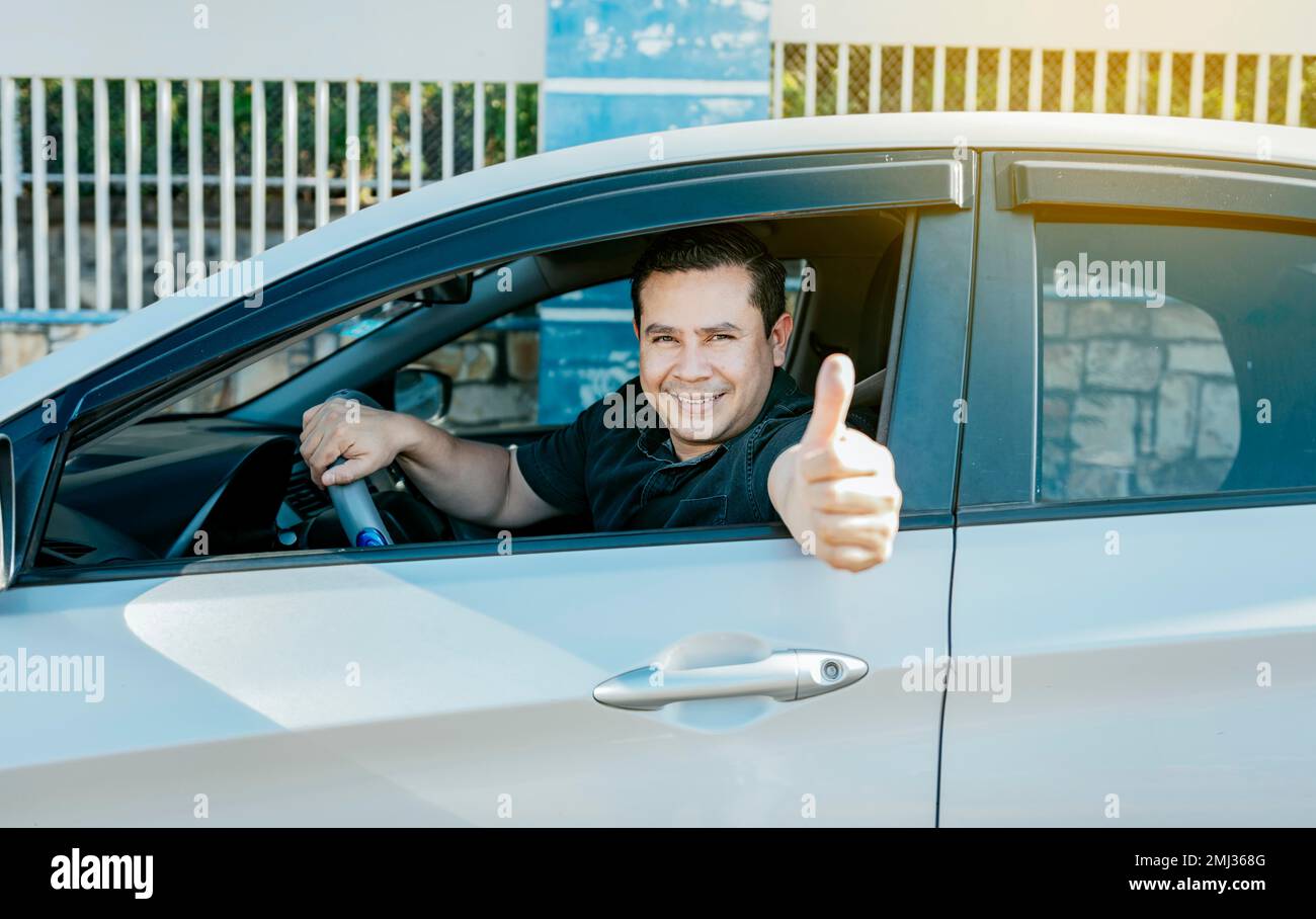 Satisfied driver man showing thumb up. Young driver man in the car ...