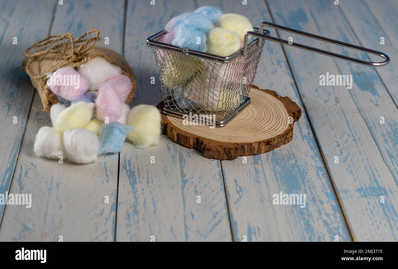 Colored cotton balls in various containers on a blue background Stock ...