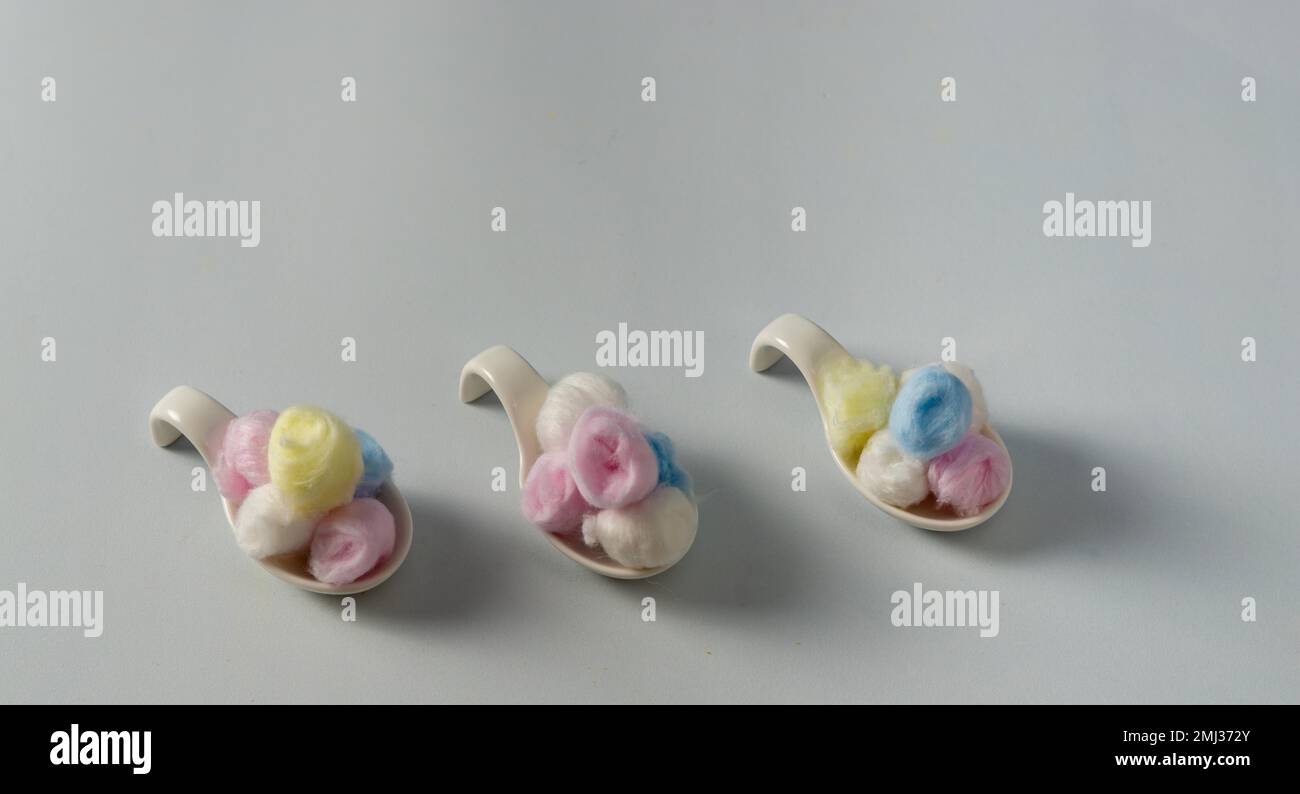 Colored cotton balls in various containers on a blue background Stock ...