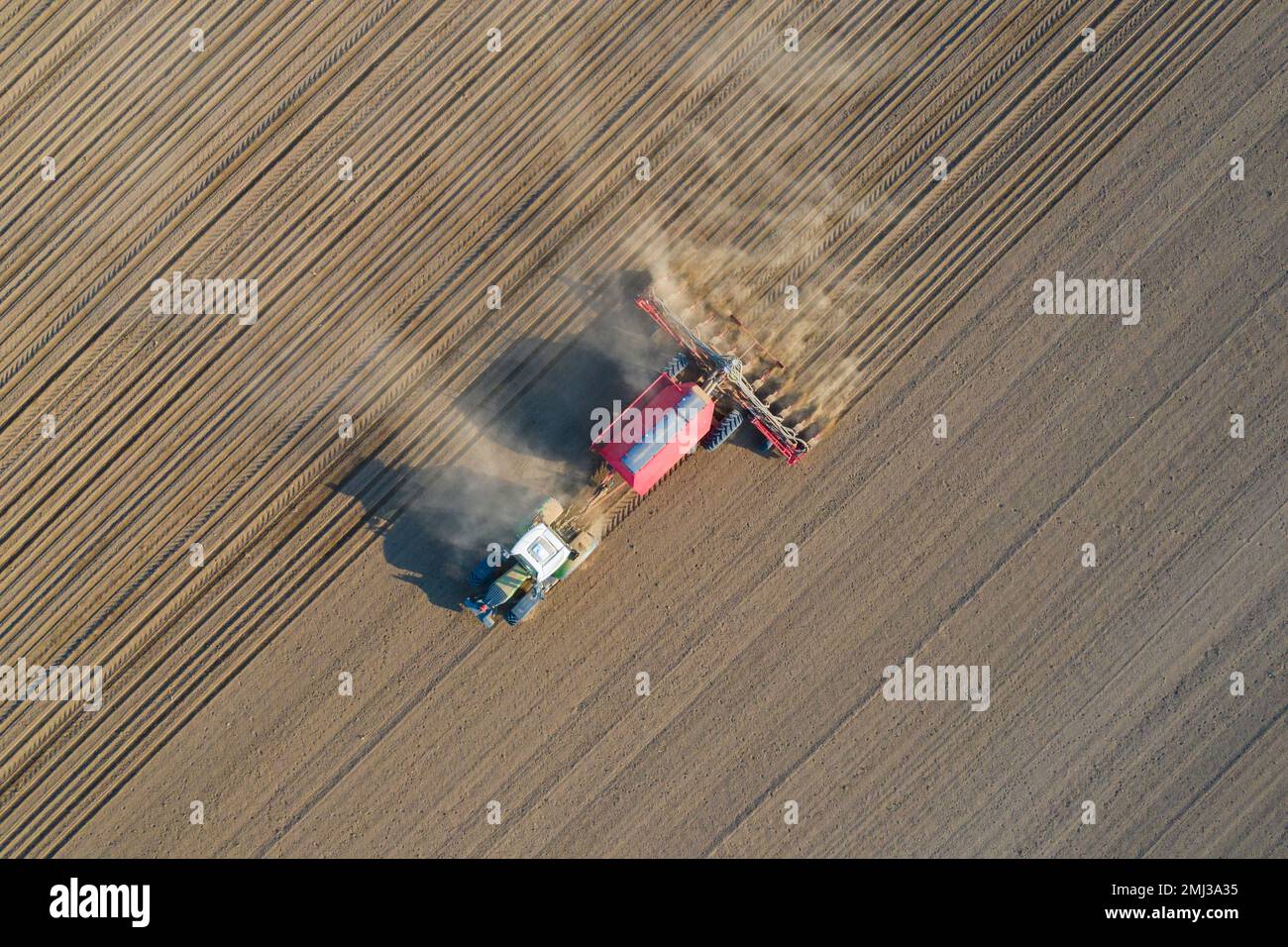 Aerial view over tractor with pneumatic seed drill, agricultural ...