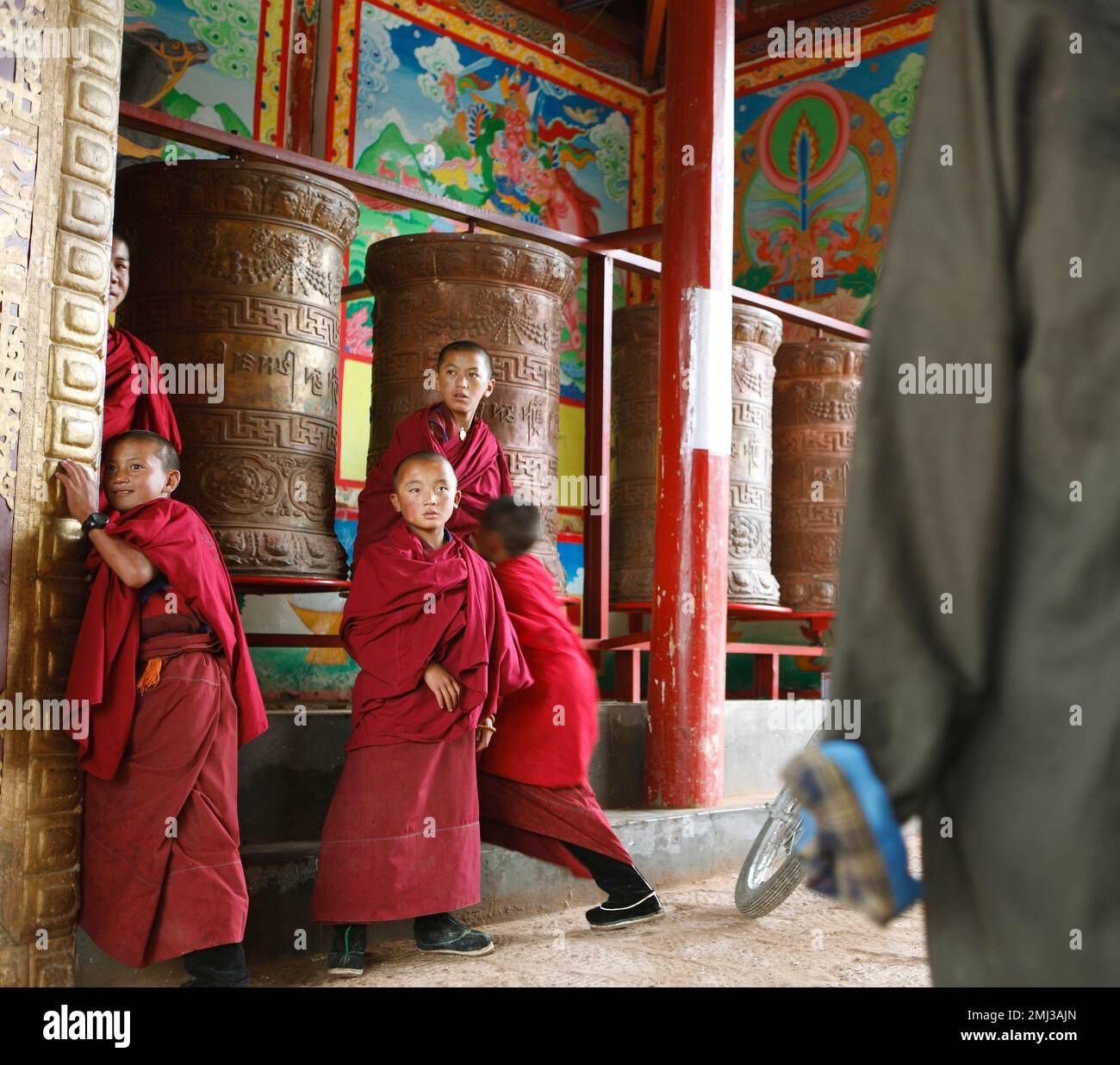 Novices playing at prayer wheels at Tseway Monastery, Ganjia, Gansu ...