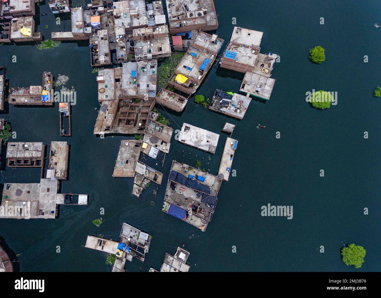 Floodwaters surround the houses by the River Ganges in Prayagraj, India ...
