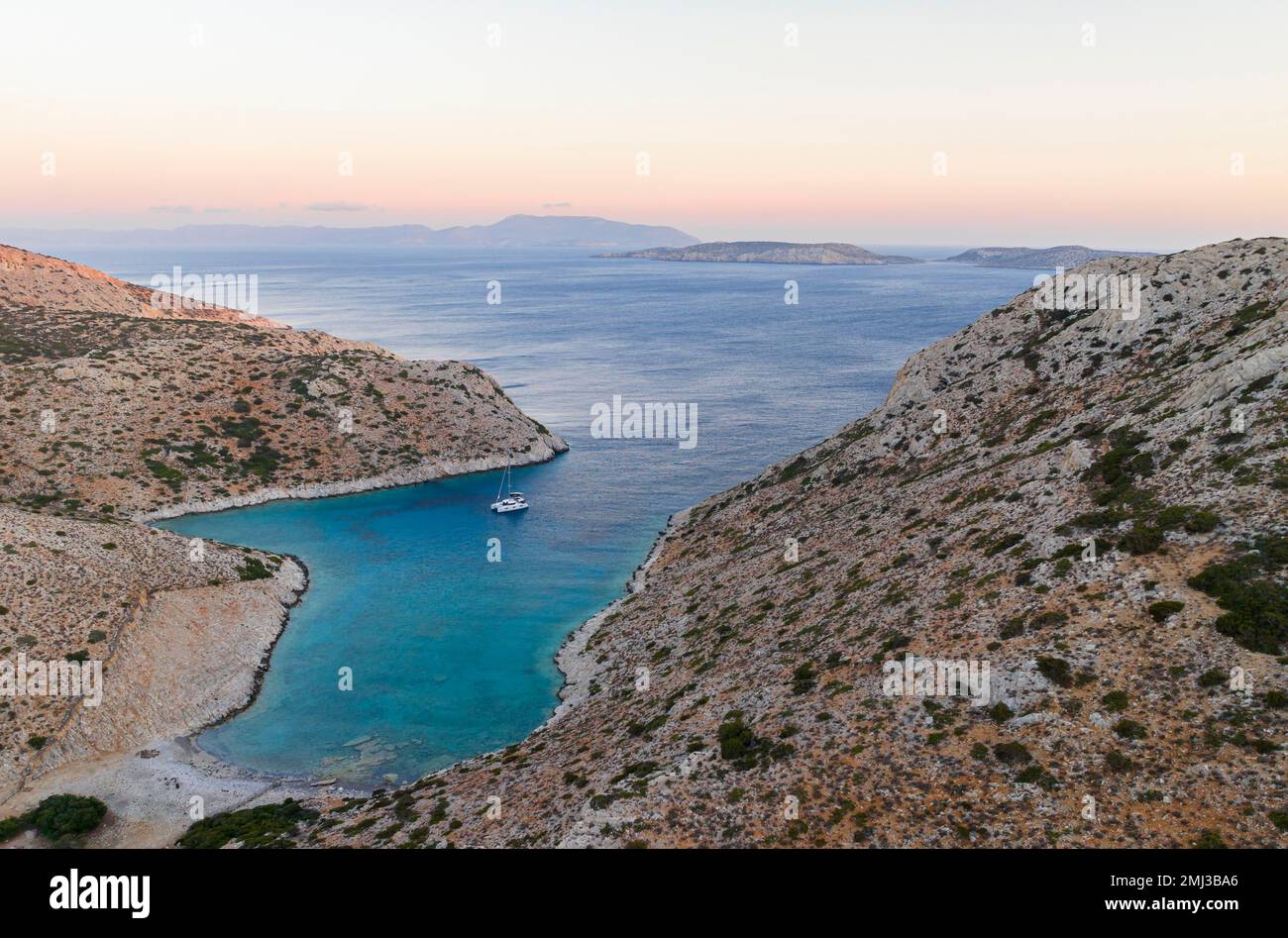 Sailing catamaran in a bay of Levitha Island, Greek Island, South Aegean Sea, Greece Stock Photo ...