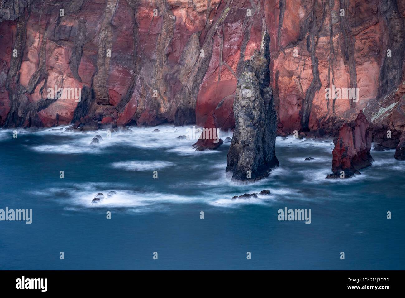 Long exposure, red rocks over blue sea, coastal landscape, cliffs and ...