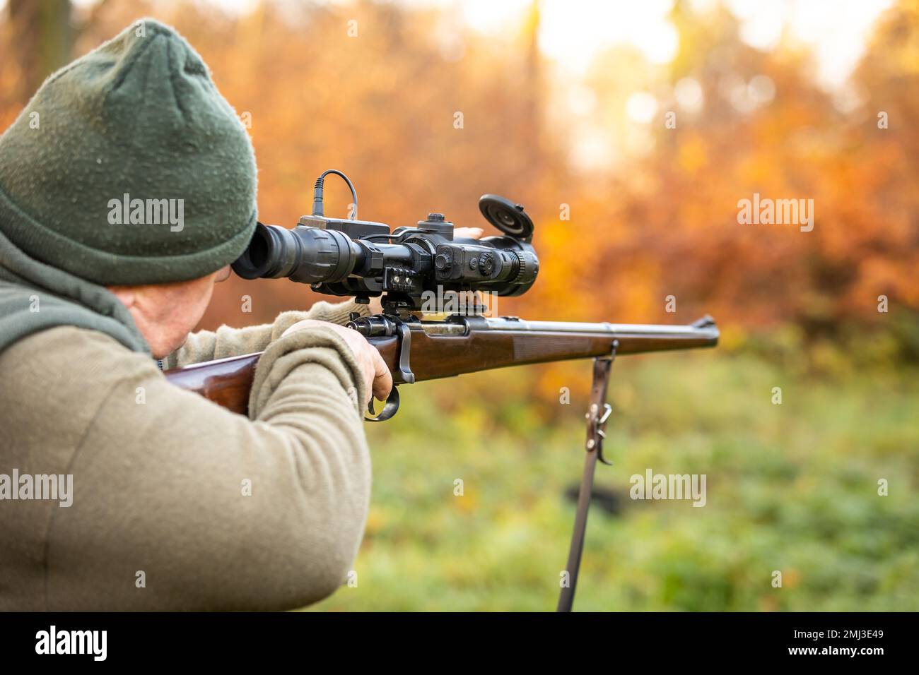 Hunter or ranger with a professional, nightvision hunting gun aiming ...