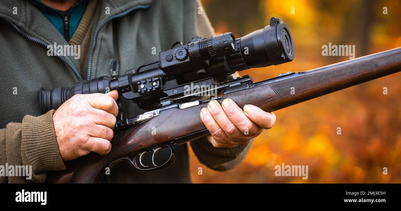 Hunter or ranger with a professional, nightvision hunting gun and ...