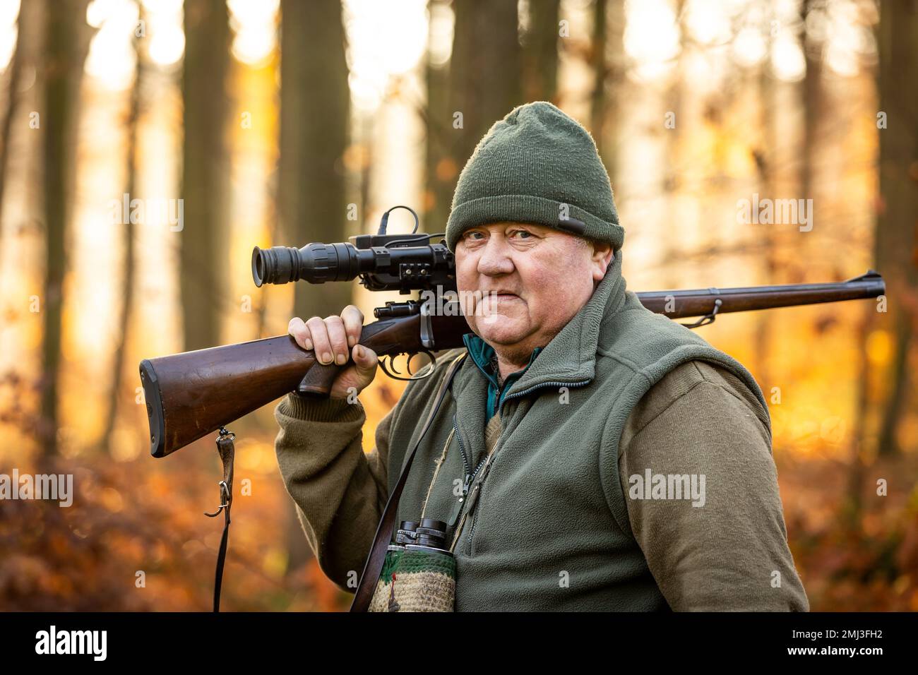 Portrait of hunter or ranger with a hunting gun and hunting form to ...