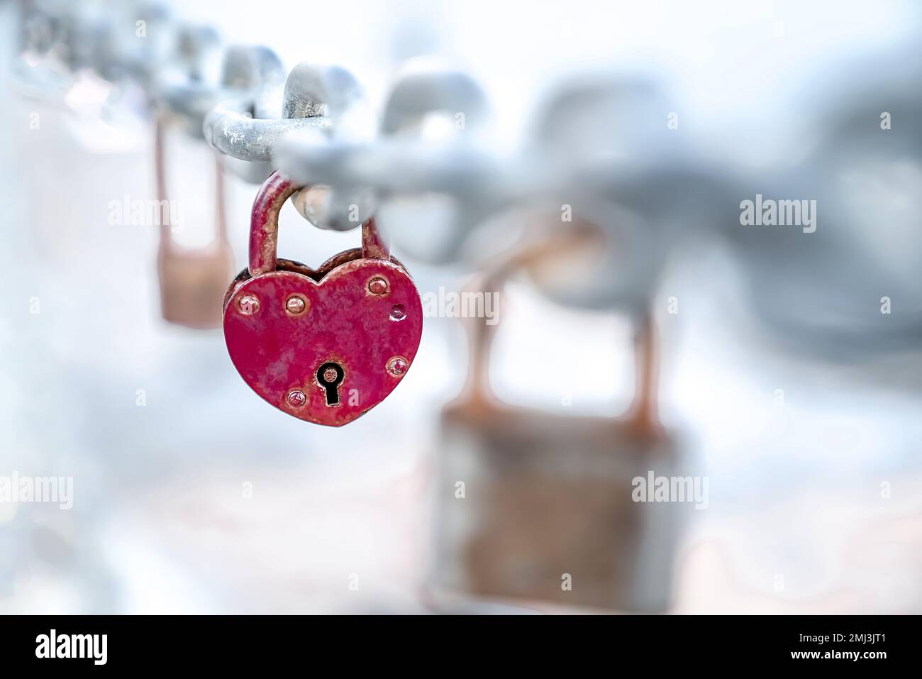 Red heart shaped lock hangs from chain, wedding custom, concept of love ...