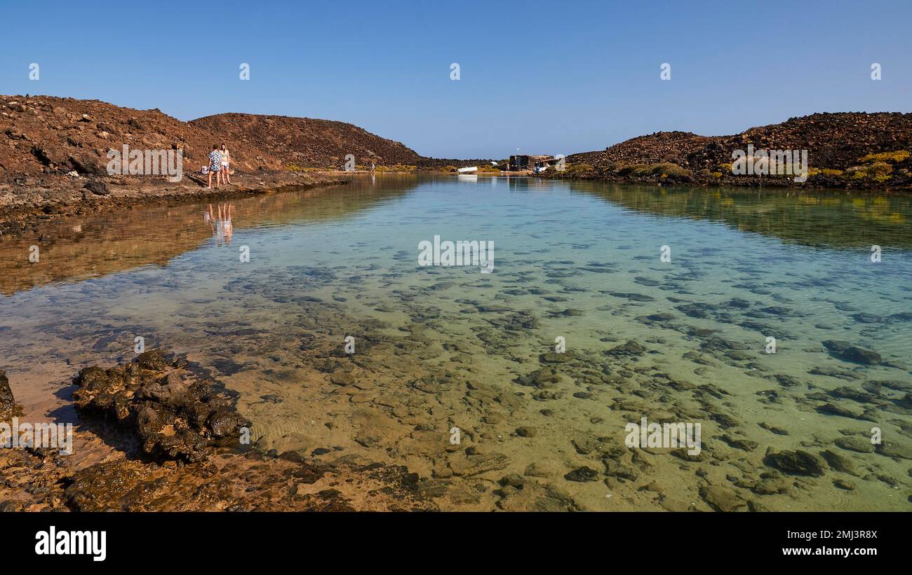 Flat lagoon, green sea, two hikers, north, Los Lobos Island, nature ...