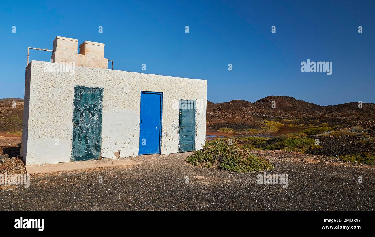 Small white building, green and blue doors, lava landscape, north, Los ...