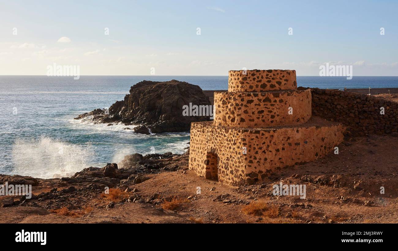 Punta de Toston, stone pyramid, surf, spray, waves, light blue sky ...
