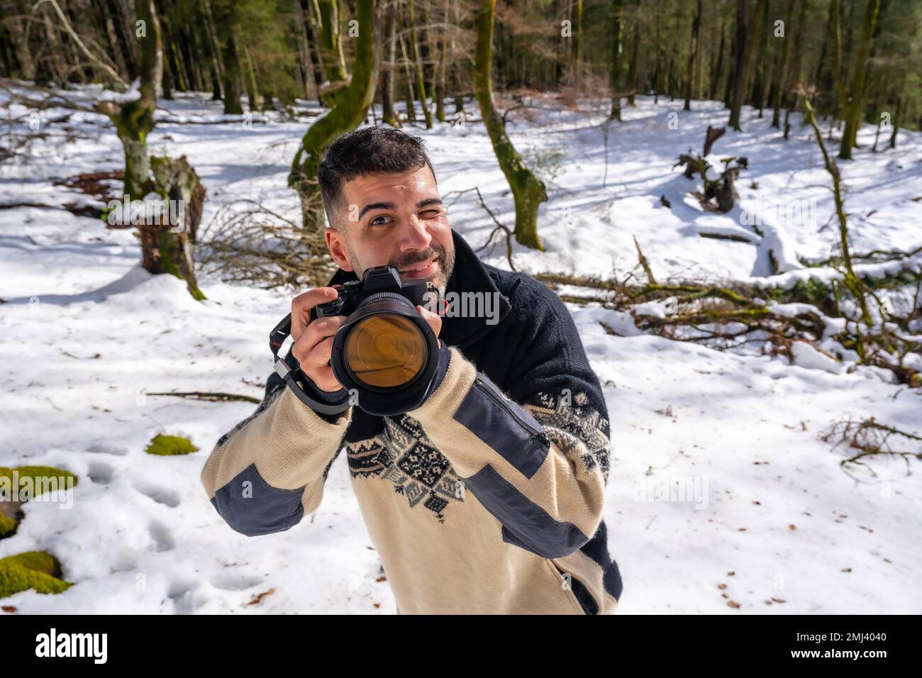 Photographer man taking a picture in the snow, enjoying winter ...