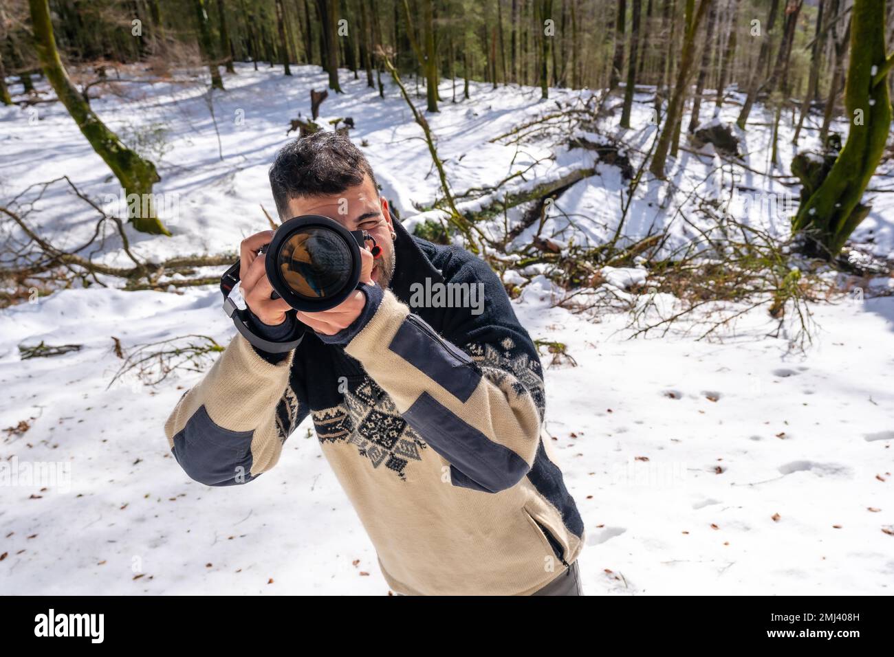 Photographer man taking a picture in the snow, enjoying winter ...