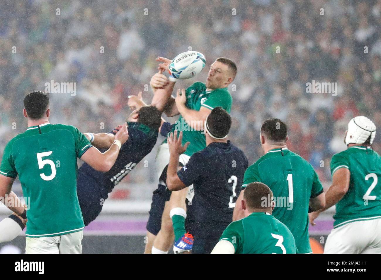 Ireland's Andrew Conway, center, leaps to take a ball jin the rain ...