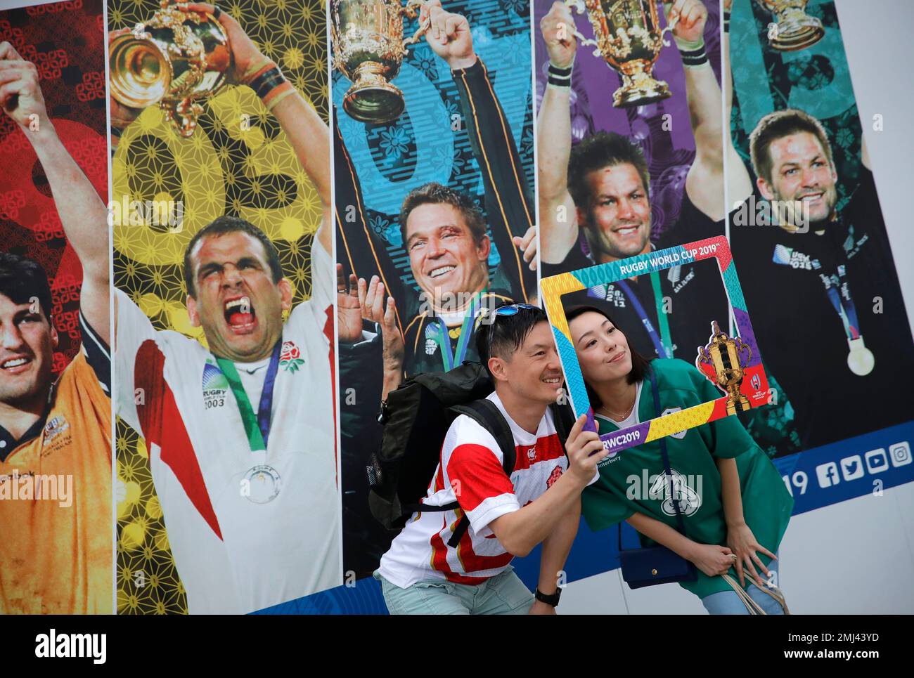 Rugby fans pose for a photo in front of a poster of former World Cup ...