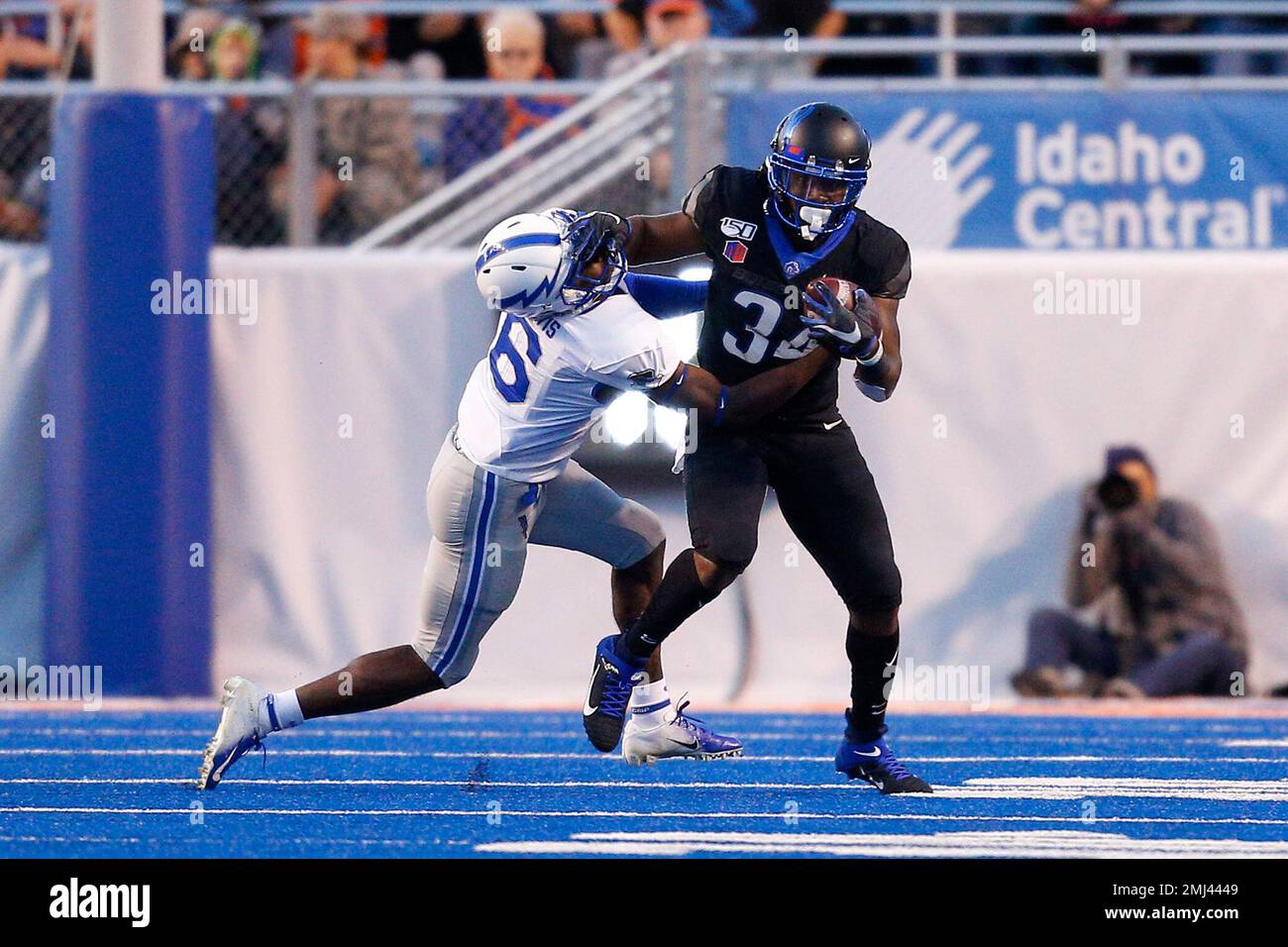 Boise State running back Robert Mahone (34) tries to push away from the ...