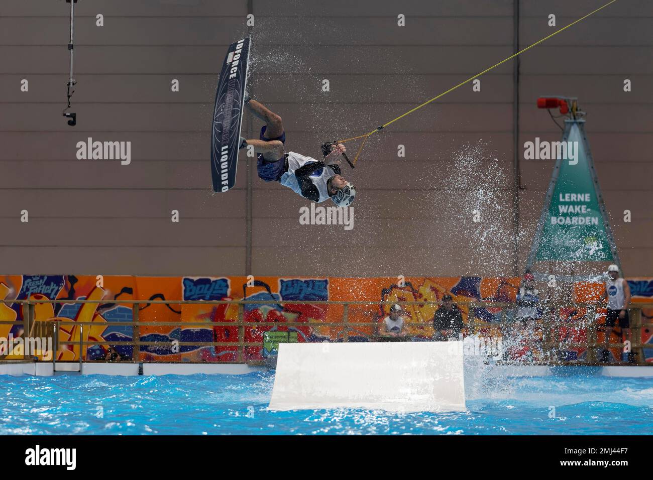 Wakeboard stunt, demonstrated in hall with indoor pool, watersports ...