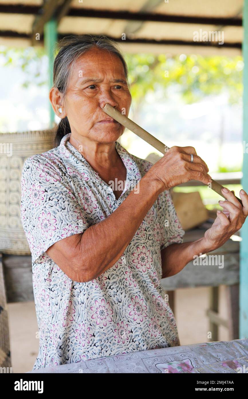 Malaysian woman playing a nose flute, Penang people, Bungan village ...