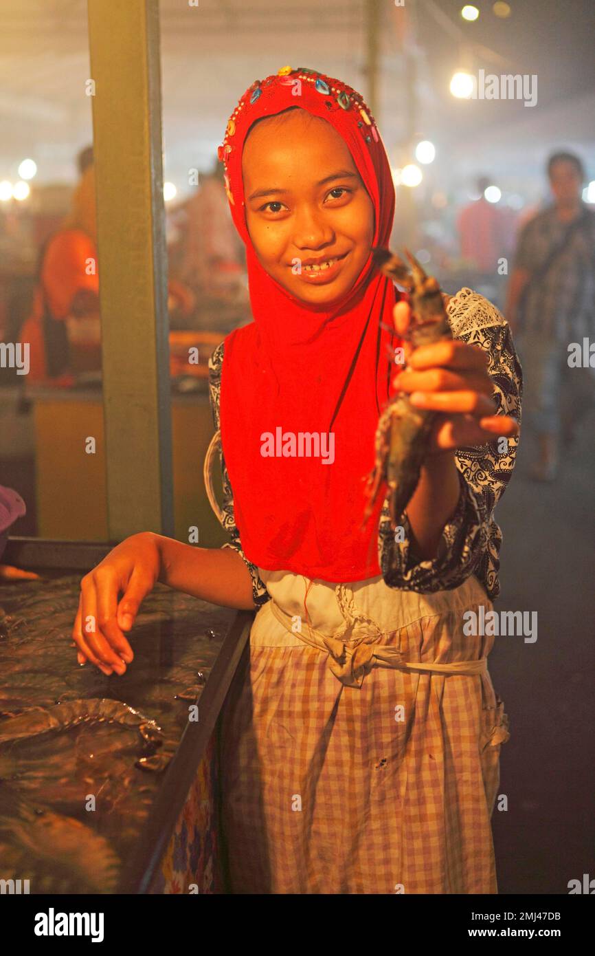 Malaysian woman with headscarf showing a crayfish at Filipino night ...