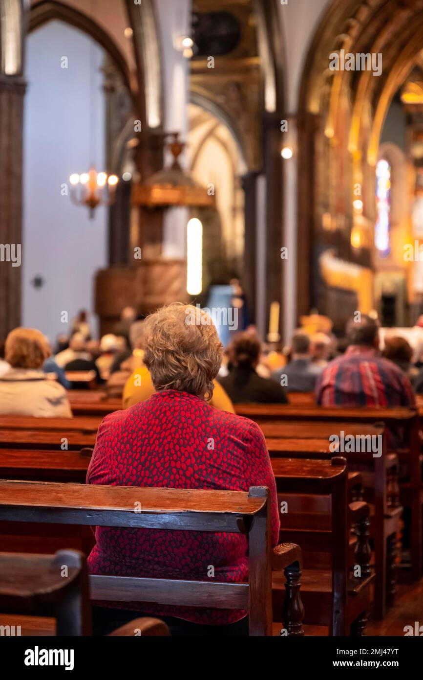 Faithful old lady in the church, interior, Funchal Cathedral, old town ...