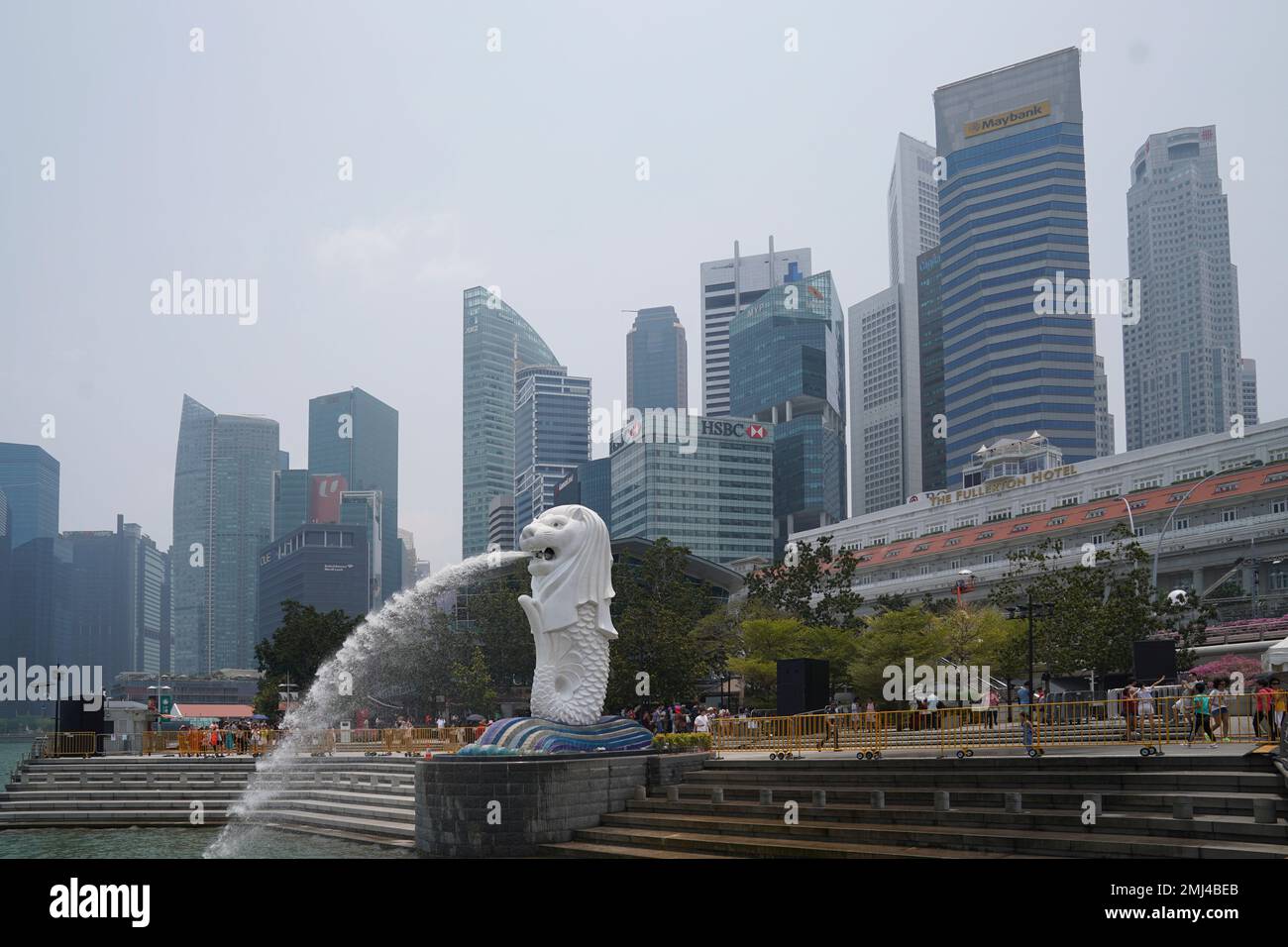 Tourists take photos in front of the iconic Merlion, mythical lion and ...