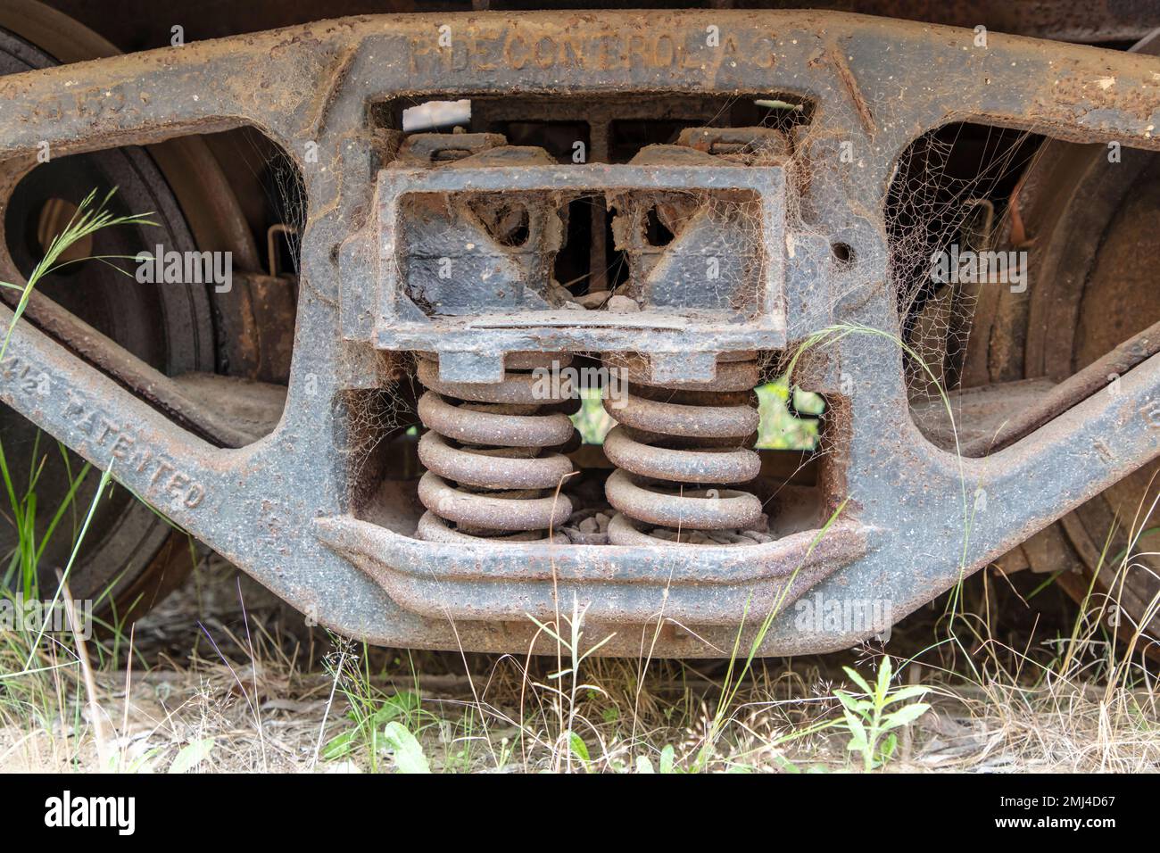 Photograph of an old and rusty suspension system covered in spiderwebs ...