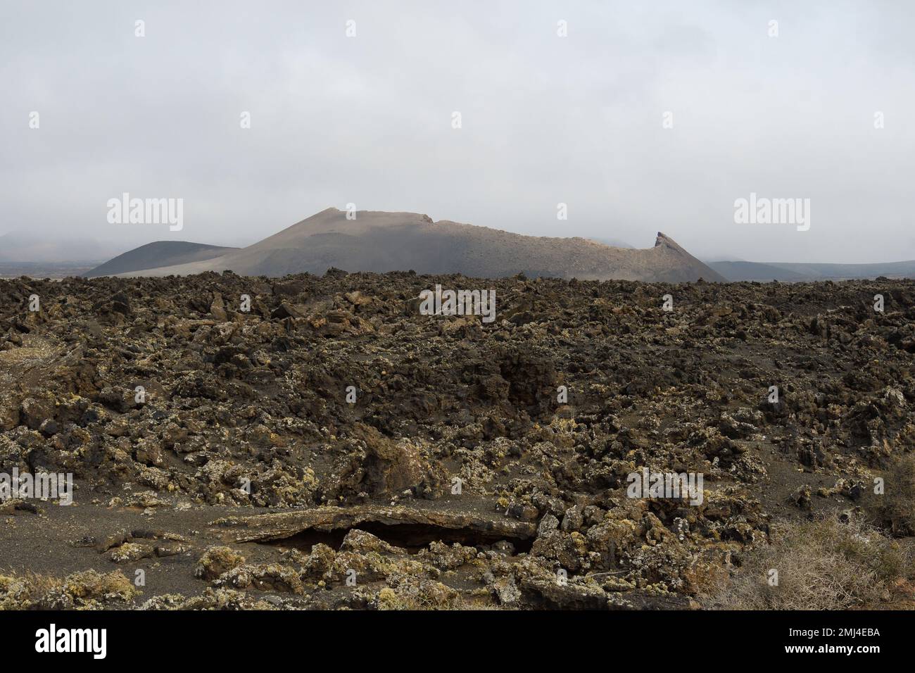 Old volcanic cone surrounded by lava in Tinajo, Lanzarote Stock Photo ...