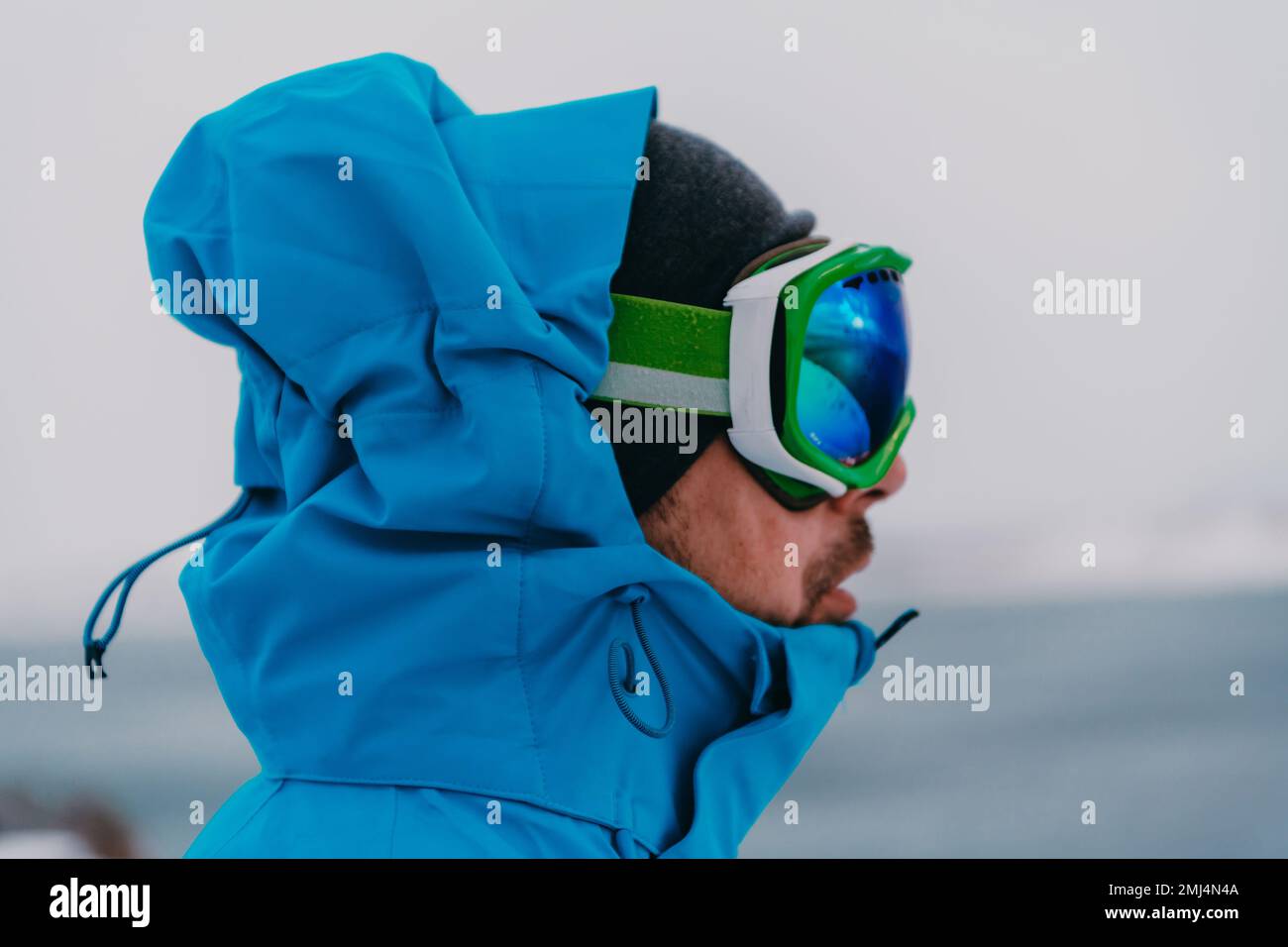 Headshot photo of a man in a cold snowy area wearing a thick blue ...