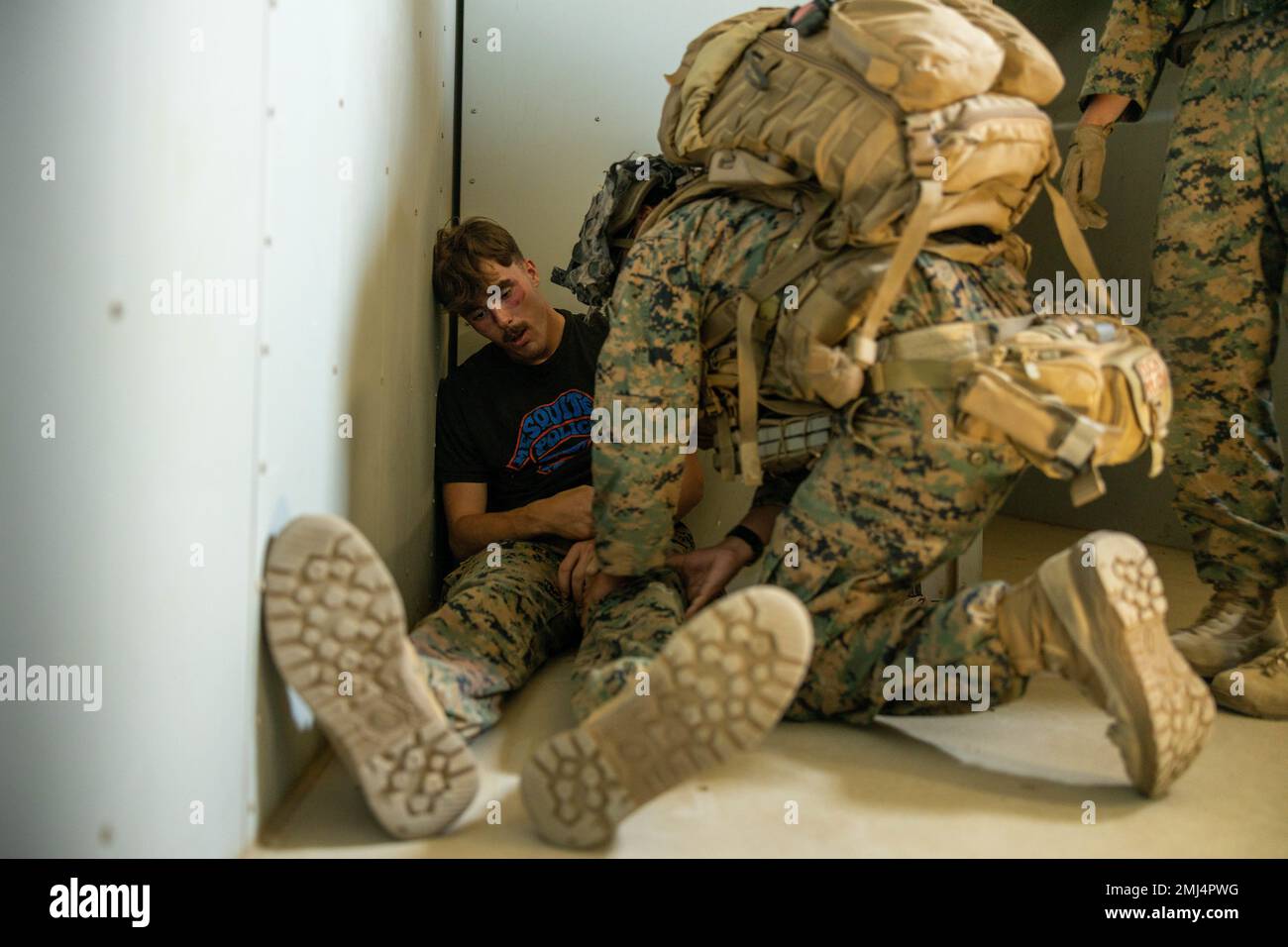A U.S. Marine with 1st Battalion, 4th Marines, 1st Marine Division, applies a tourniquet to a ...