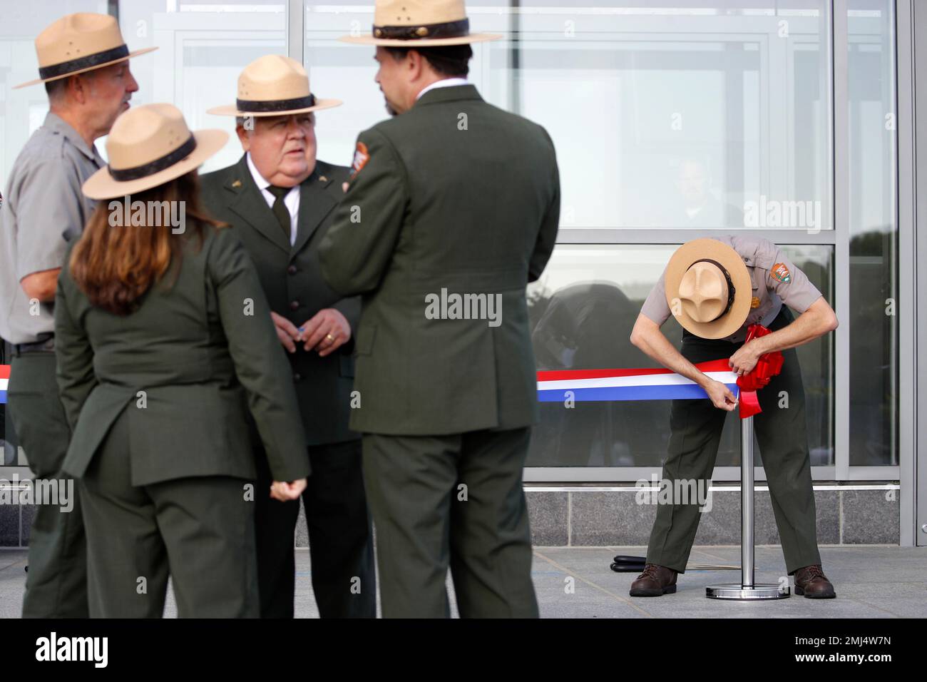 A National Park Service park ranger prepares a ribbon for a ribbon ...