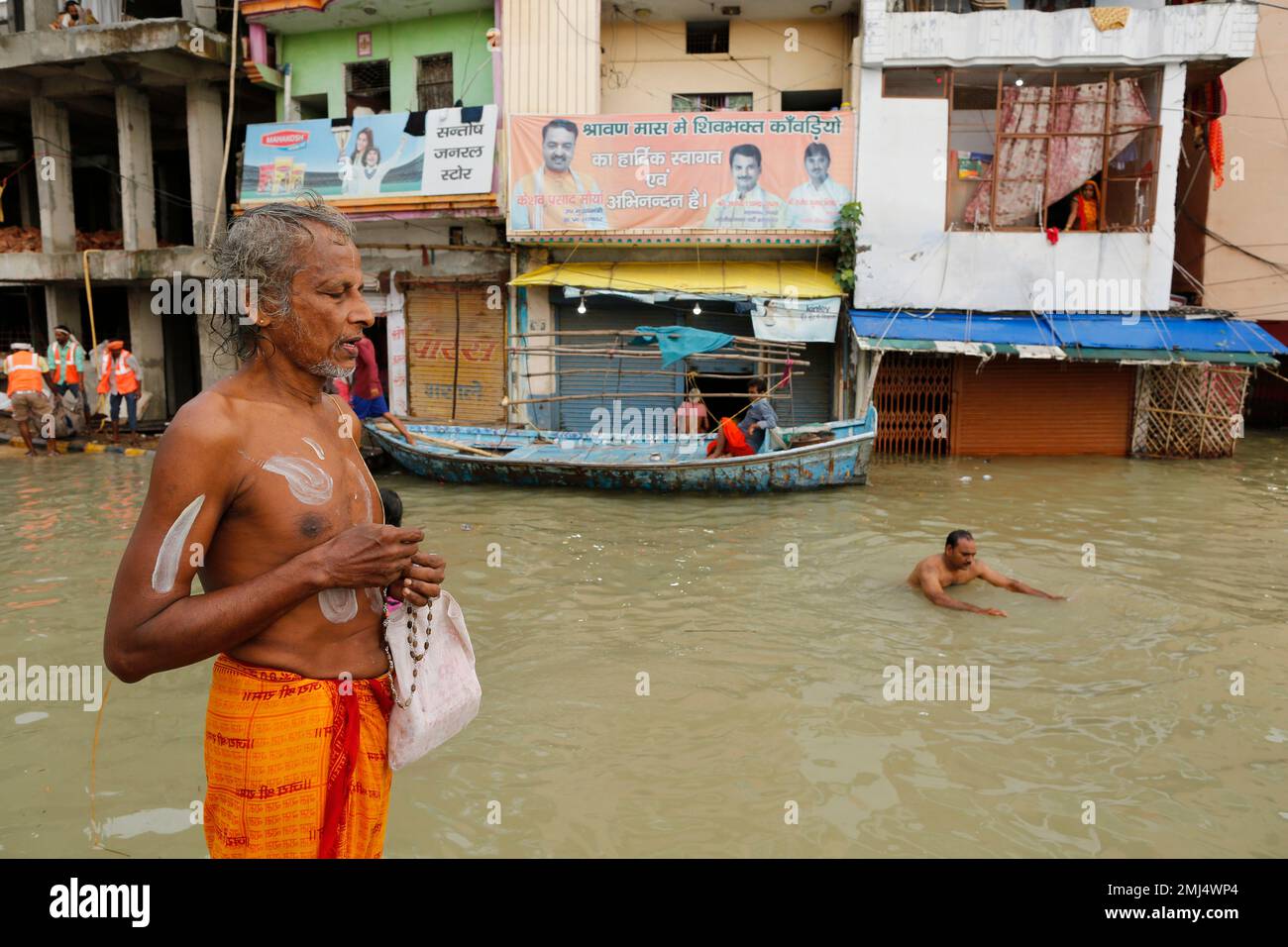 A Hindu devotee offers prayers in a flooded River Ganges in Prayagraj ...