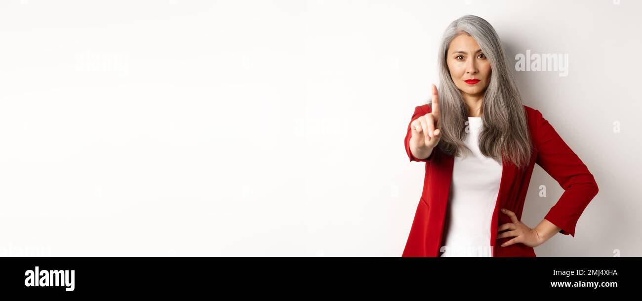 Serious and disappointed asian businesswoman showing stop gesture ...