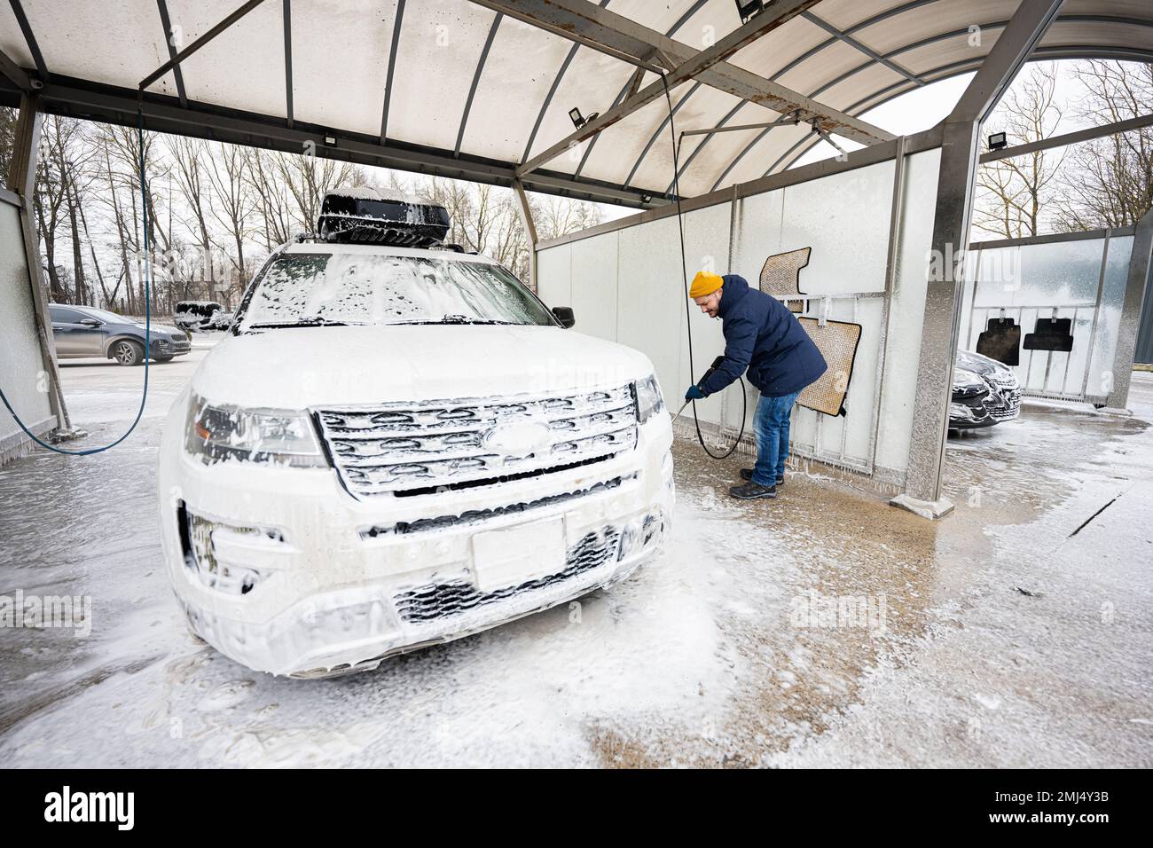 Man washing high pressure water american SUV car with roof rack at self ...