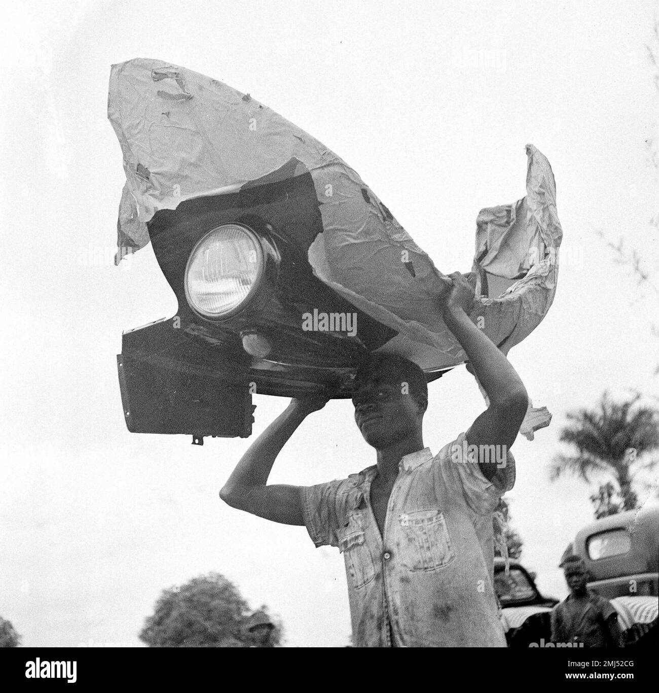 A worker at an outdoor assembly line for trucks by Chevrolet holds a ...