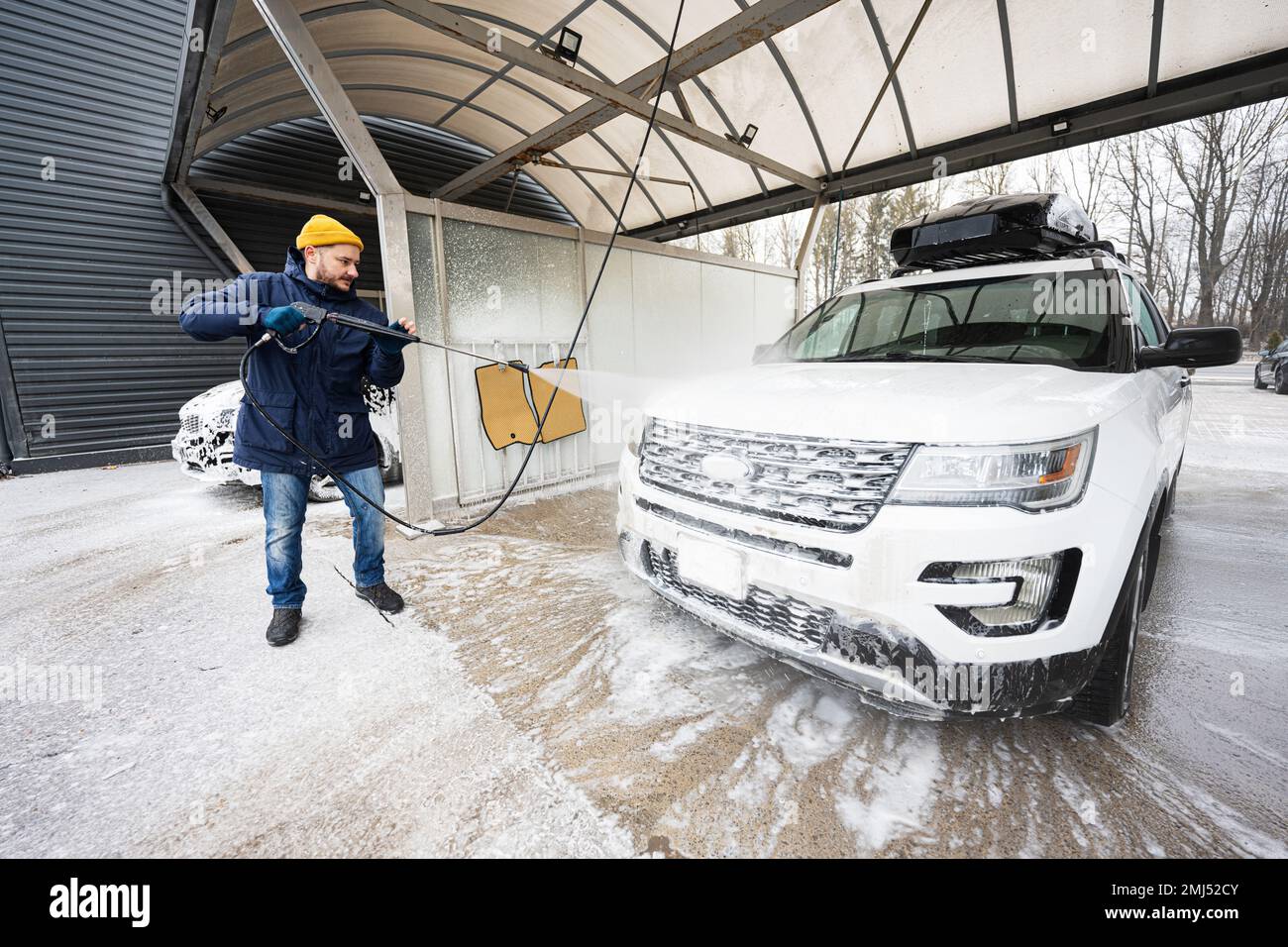 Man washing high pressure water american SUV car with roof rack at self ...