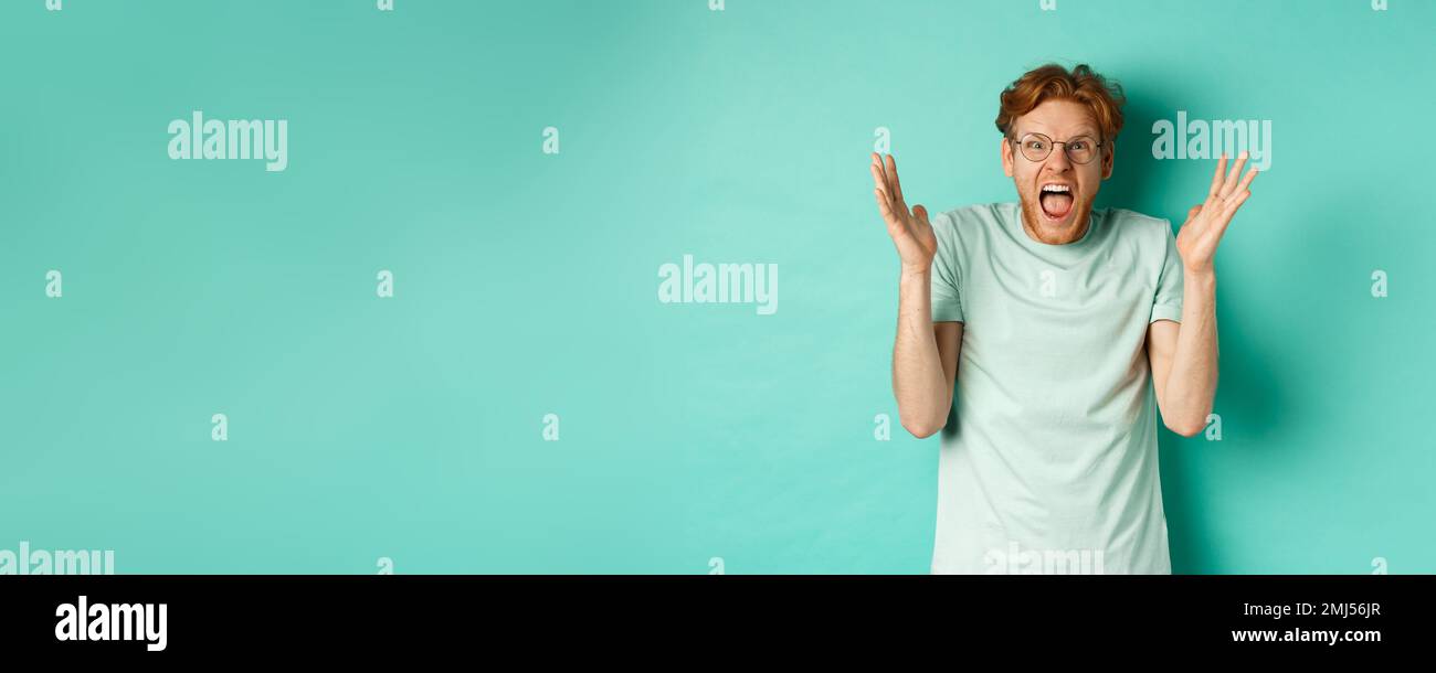 Portrait of distressed and angry redhead guy losing temper, shouting ...