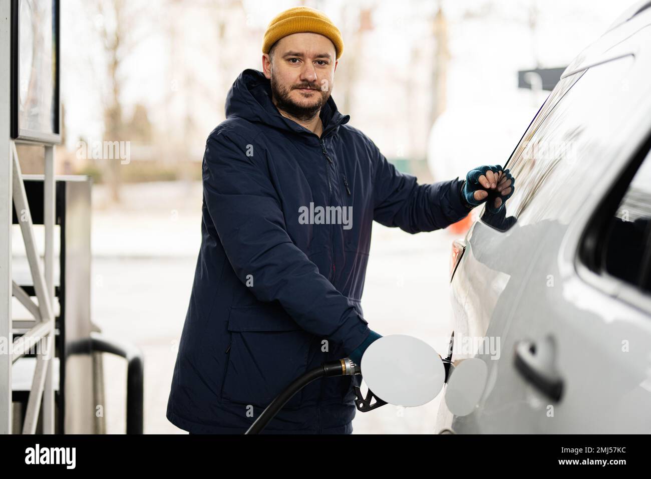 Man refueling his american SUV car at the gas station in cold weather ...